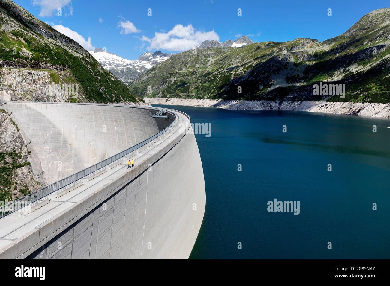 Mother and son walking on an alpine dam on reservoir lake ...