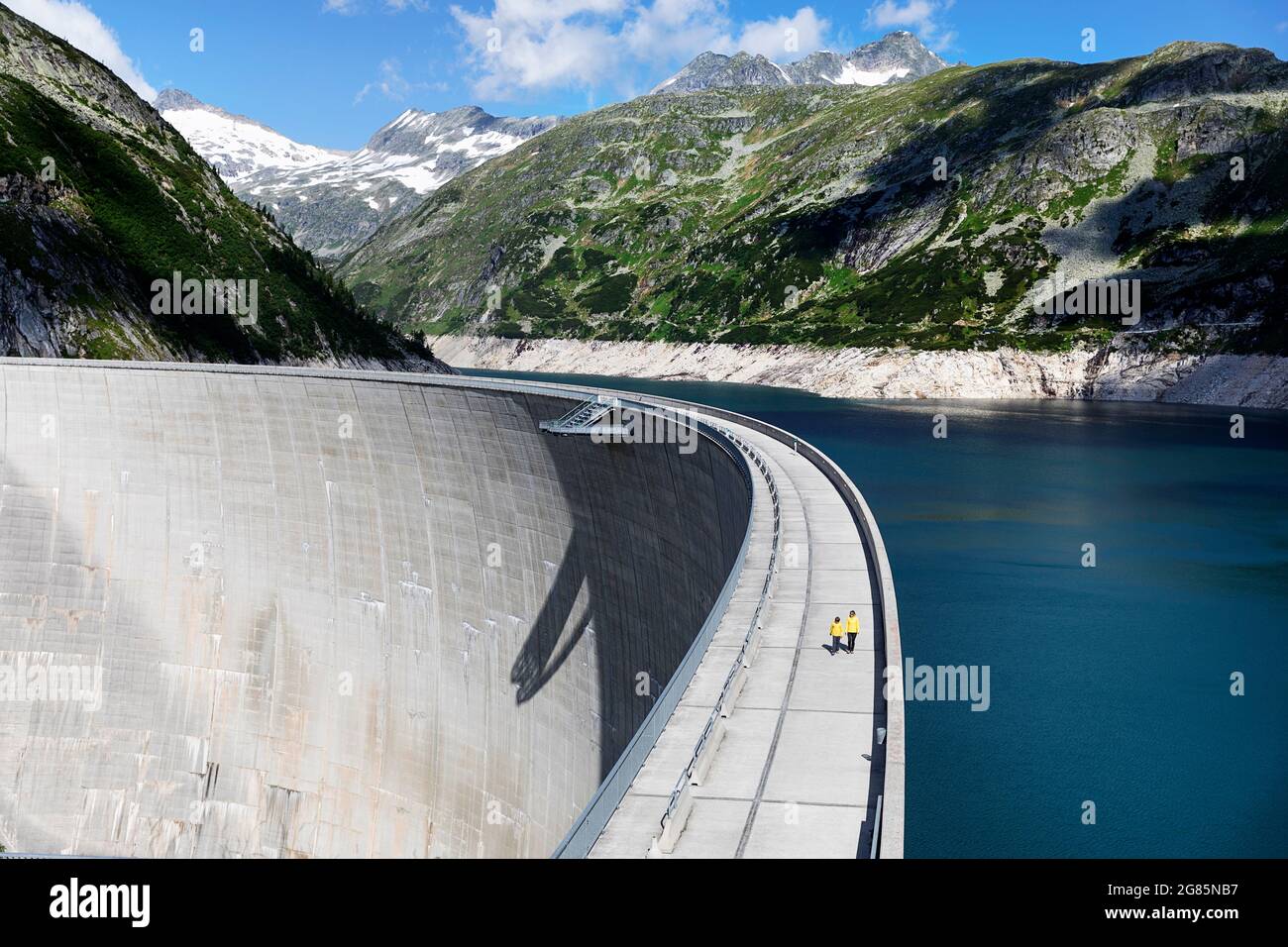 Mother and son walking on an alpine dam on a summer day on reservoir ...