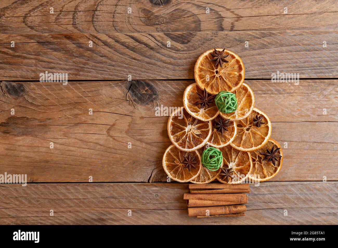 Christmas tree made of dried oranges, cinnamon and star anise on wooden ...