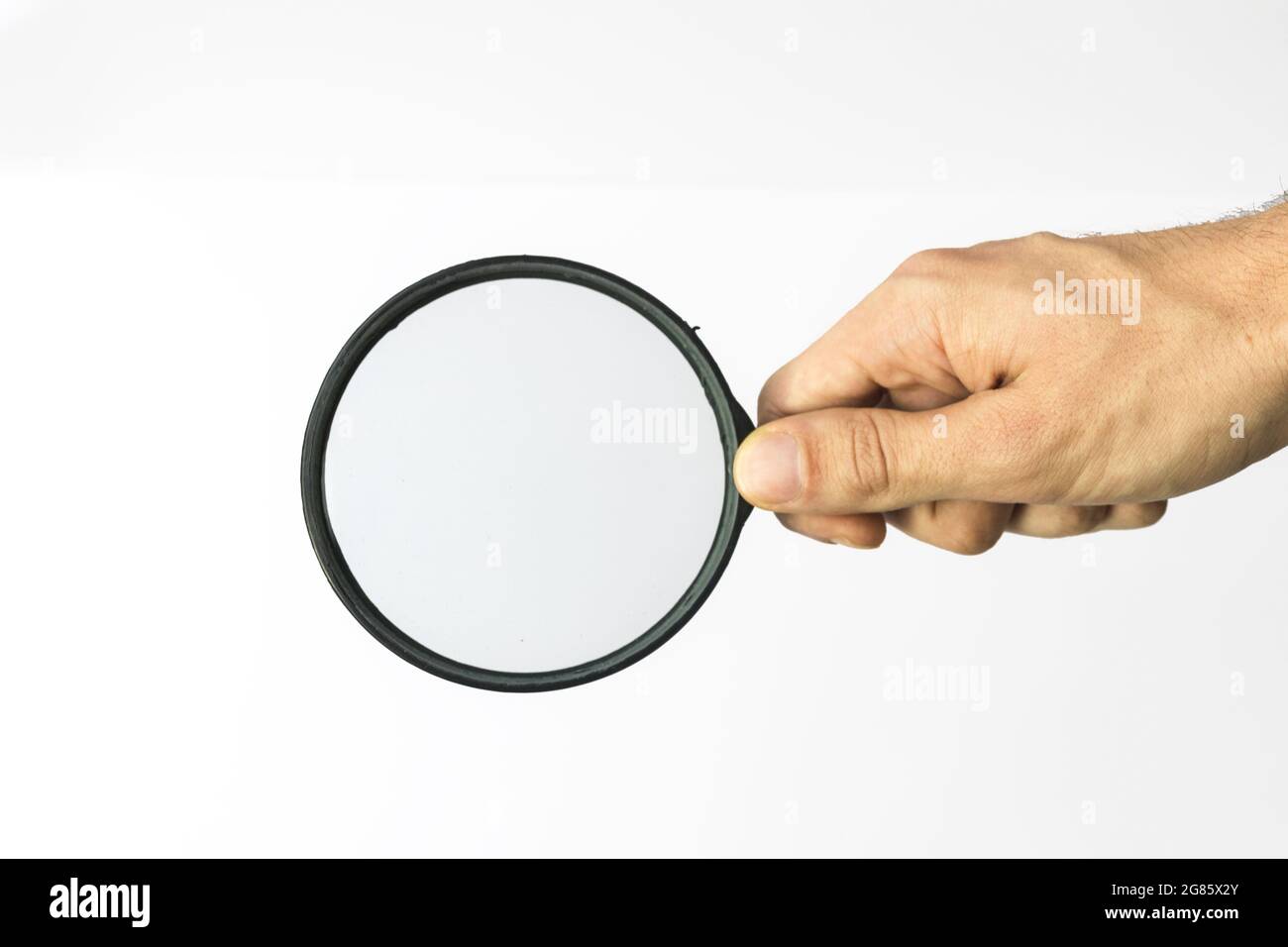 Hand holding a magnifier on a white background Stock Photo - Alamy