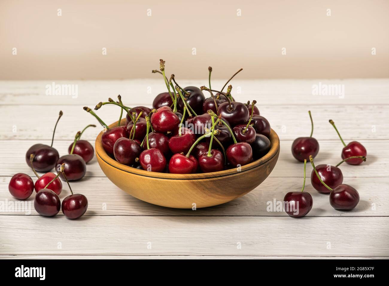 Bowl full of ripe red dark cherries on wooden table surface as Source ...
