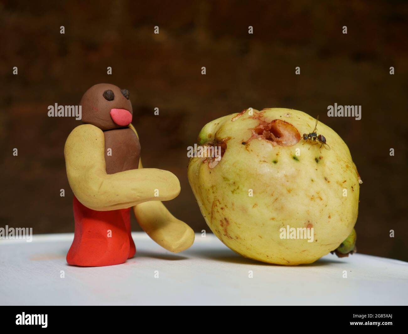 hand made clay man cartoon character standing with rotten guava organic ...