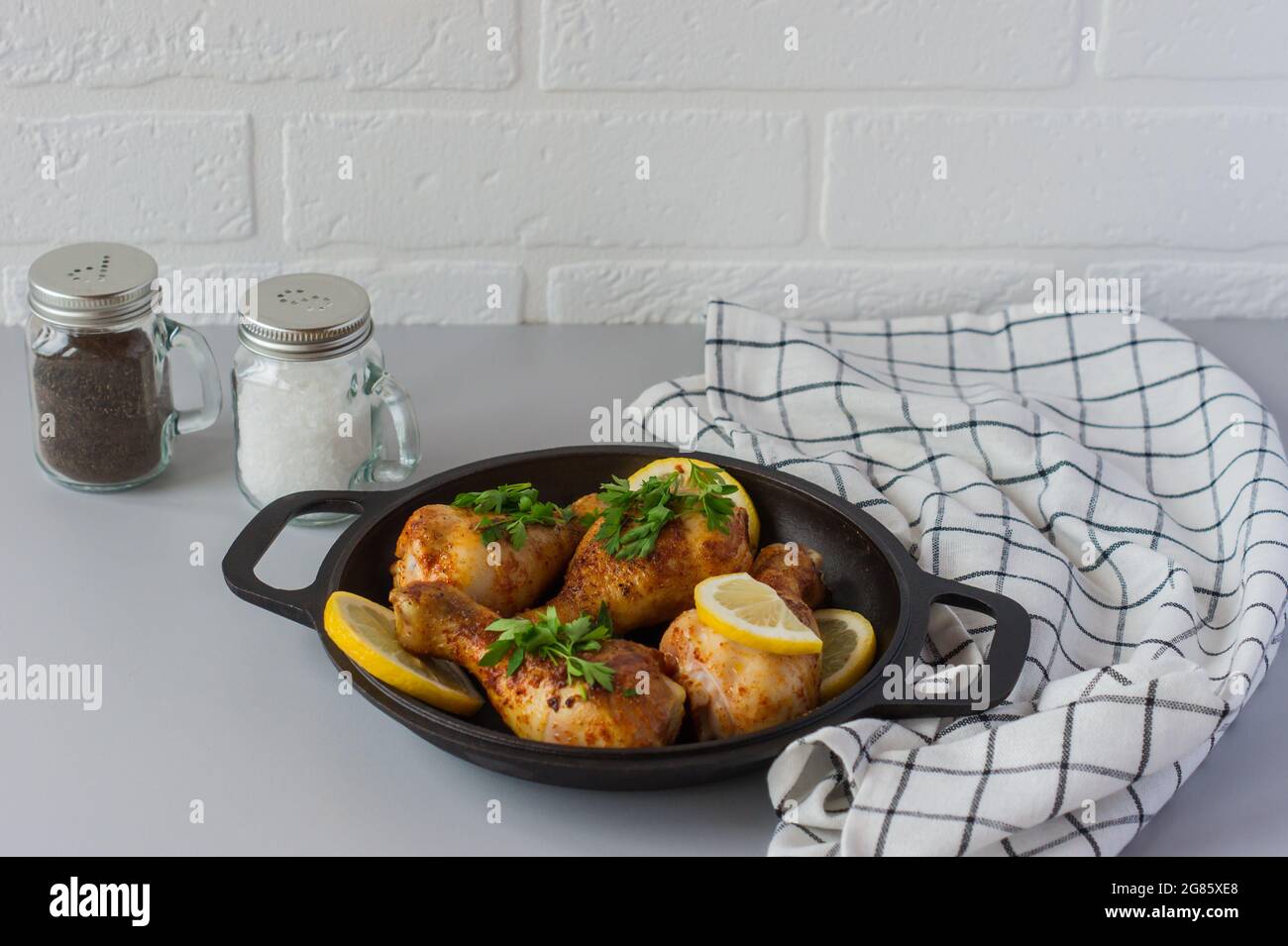 fried quarters chicken legs with herbs, honey, spices and lemon close ...