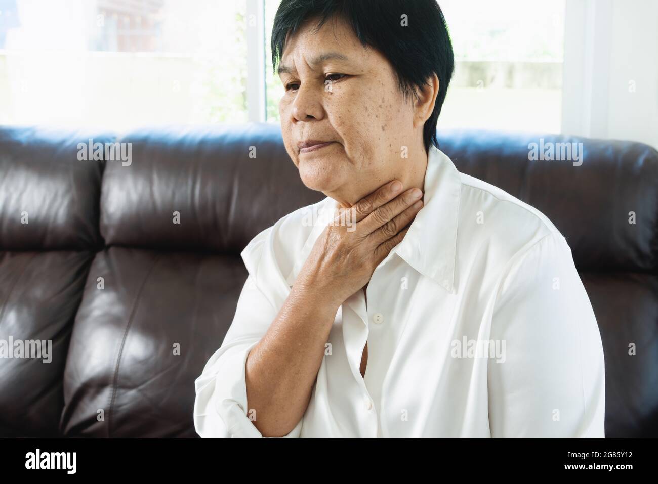 Senior adult women touching the neck feeling unwell coughing with sore ...