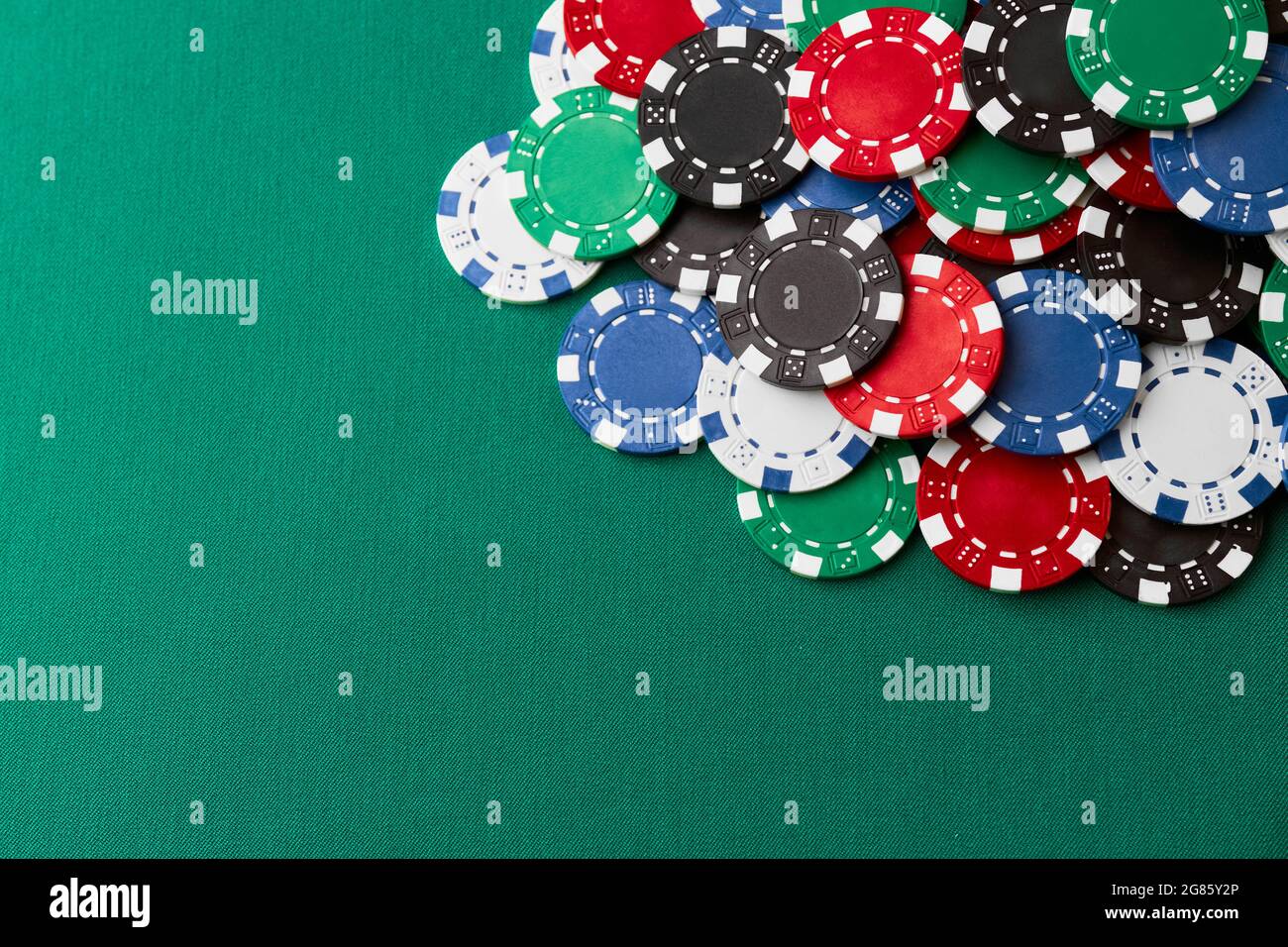 Pile of Casino pocker gambling chips on green table Stock Photo - Alamy