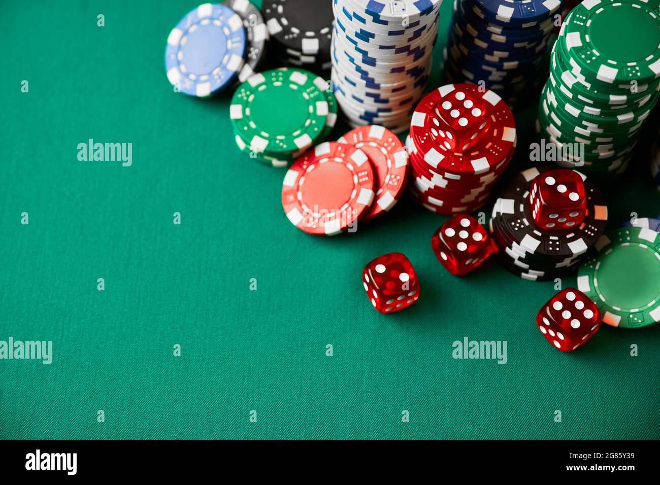 Pile of Casino pocker gambling chips and dices on green table Stock ...