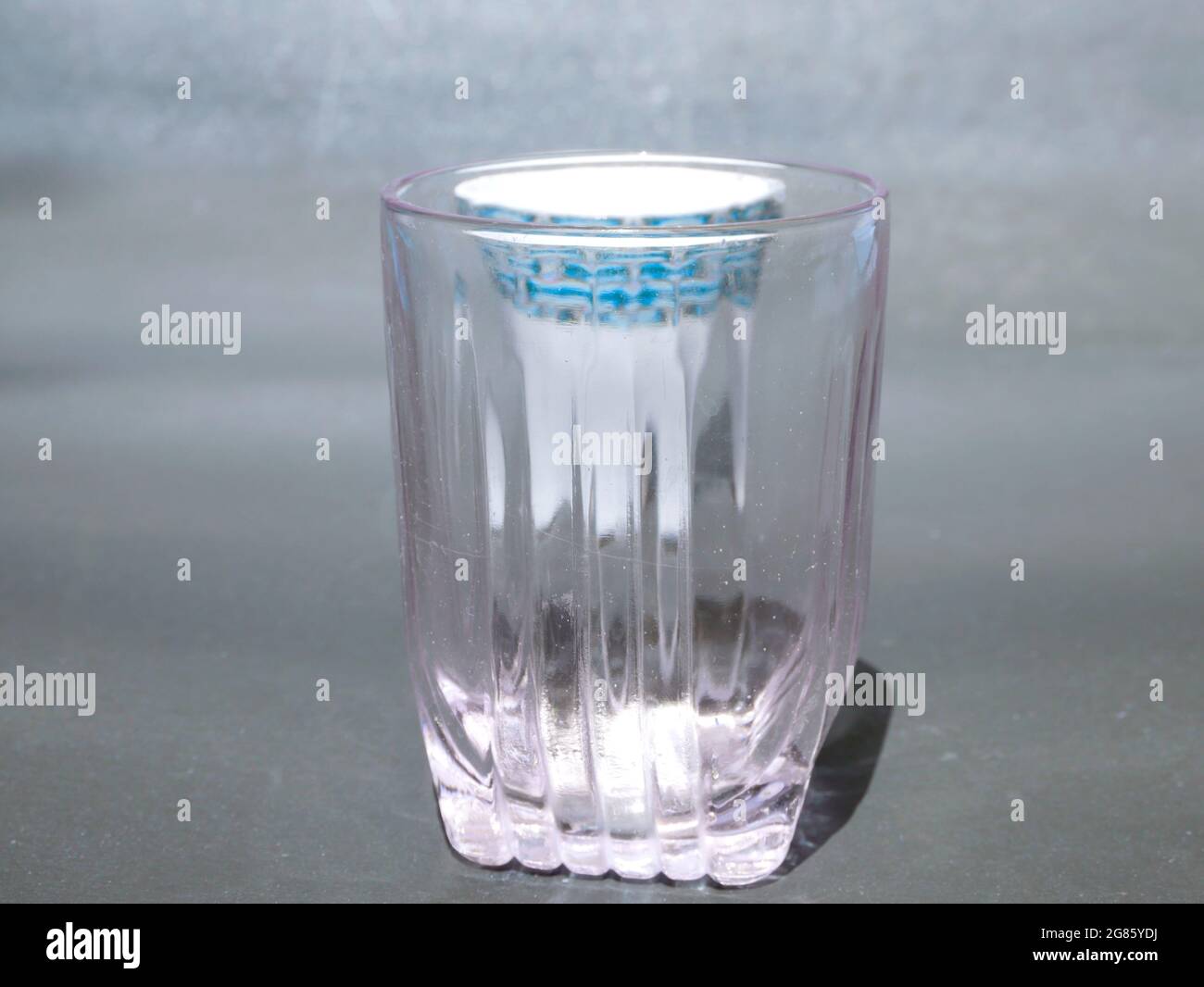 Water glass presented with tea cup behind reflection on center object ...