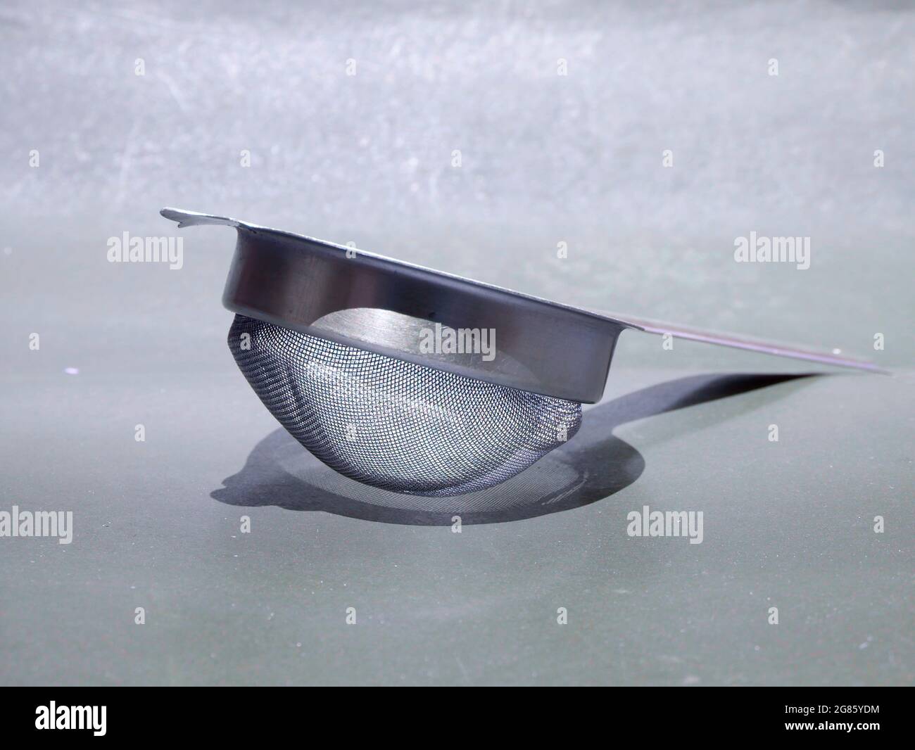 aluminium metal tea filter kept on gray surface, kitchen cutlery ...