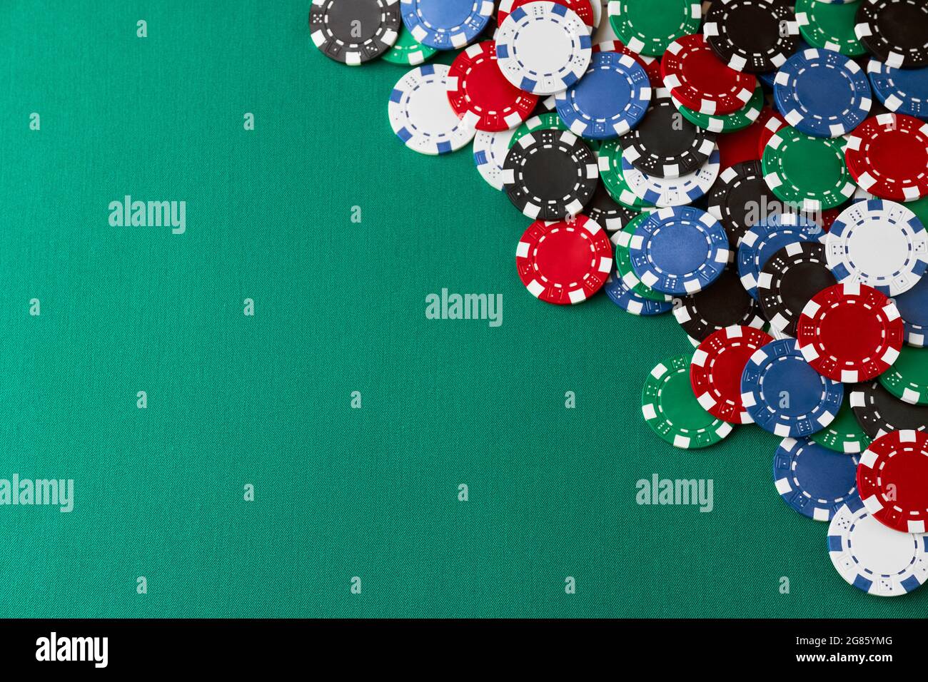 Pile of Casino pocker gambling chips on green table Stock Photo - Alamy