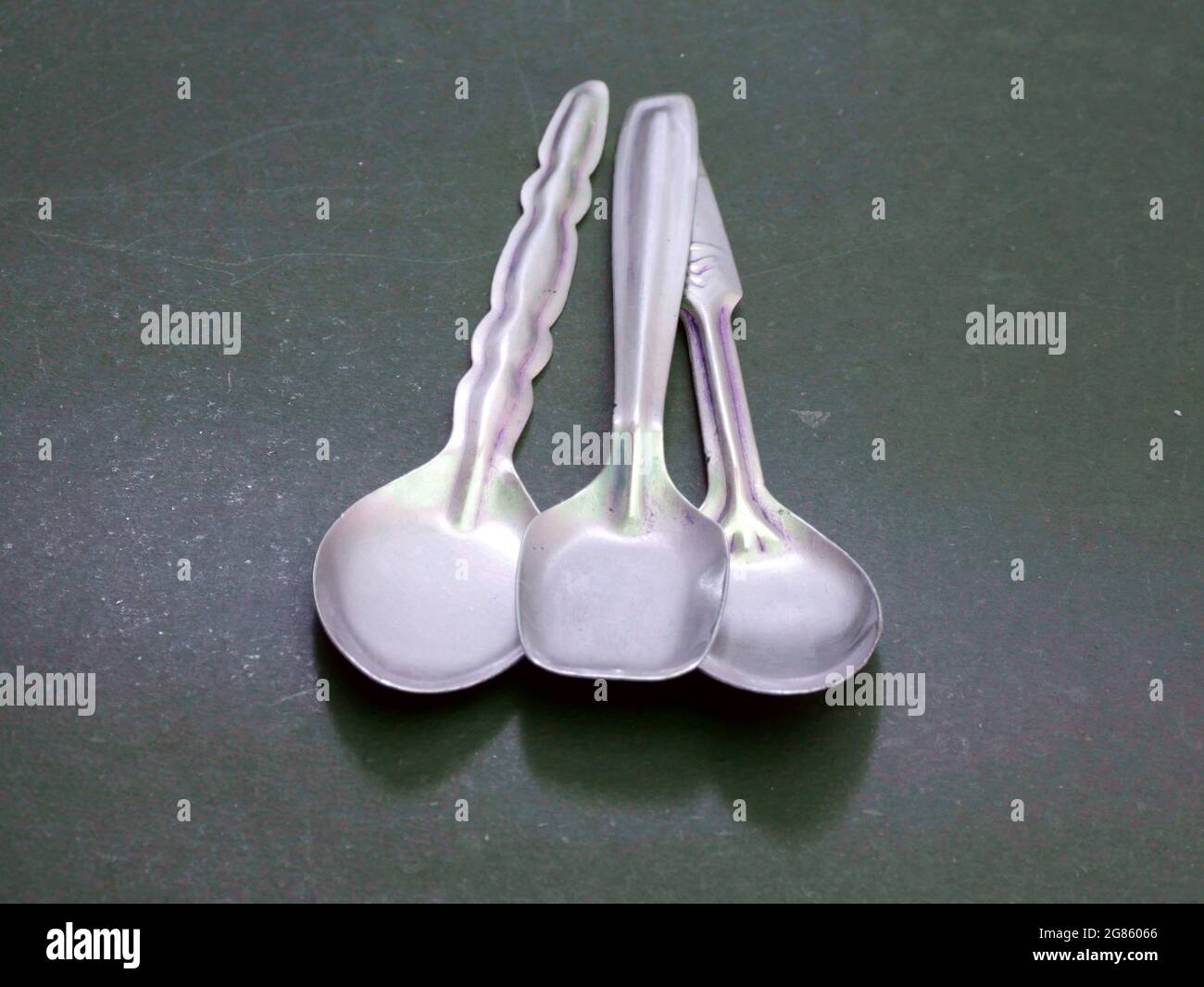 three Stainless steel spoon combination displayed on gray backdrop ...