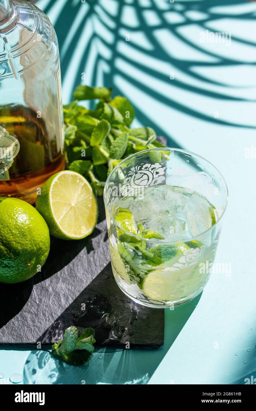 Summer cocktail Mojito preparation: lime slices, peppermint and ice on ...