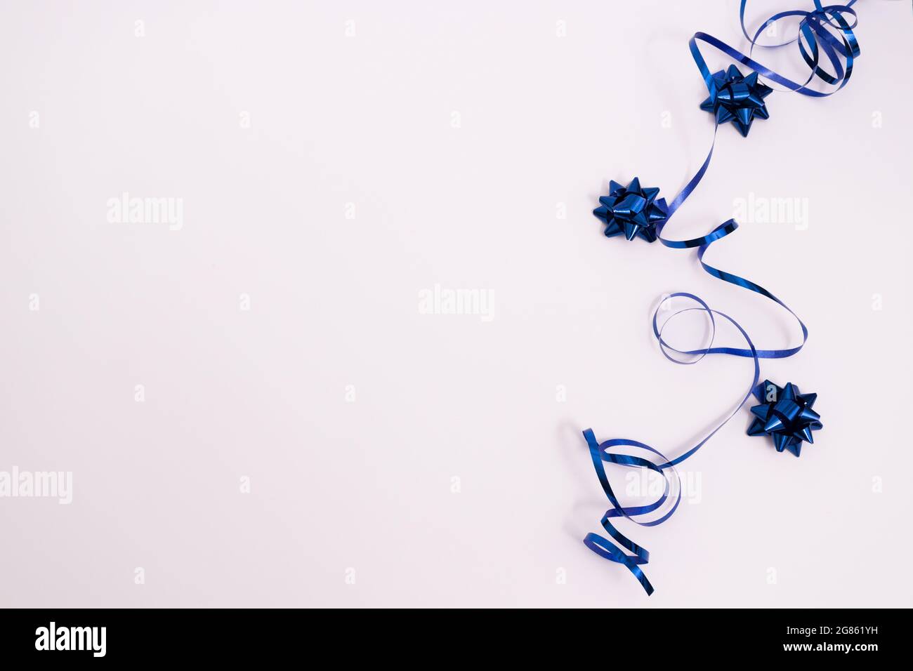Curly and glossy ribbon with bows on a white background with a space ...