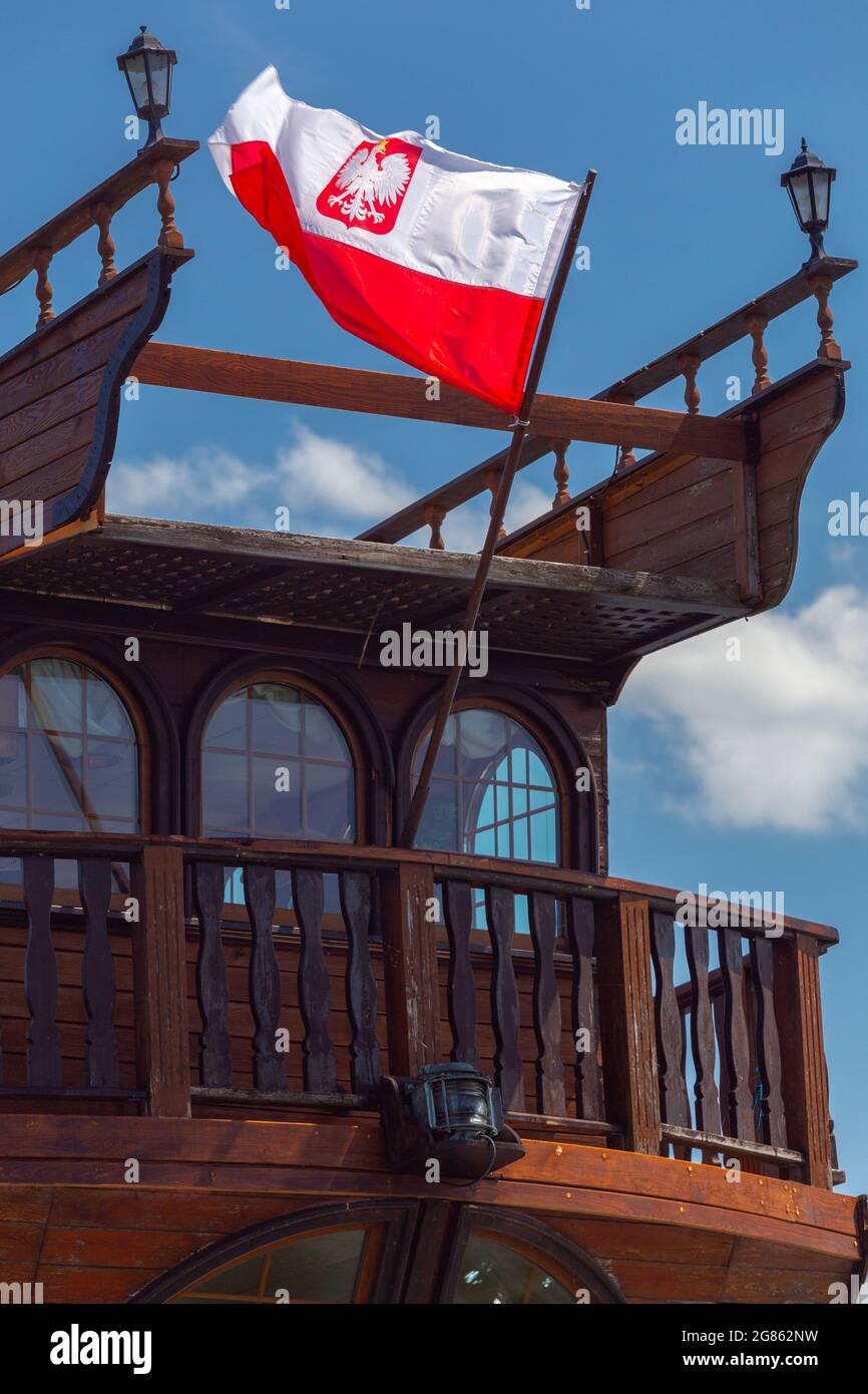 Waving Polish national flag at the stern of an old wooden ship ...