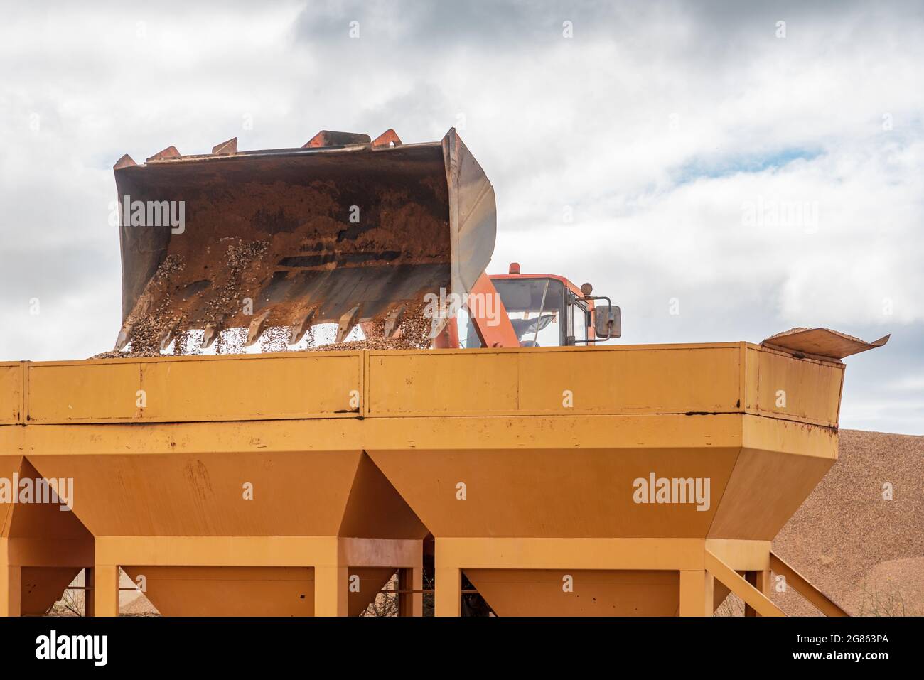 Bucket of an excavator pouring sand into silos Stock Photo - Alamy