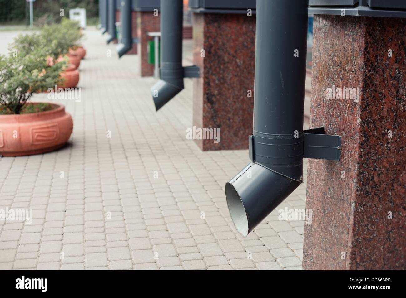 Stainless steel shiny downpipe at the corner of the house, close up ...