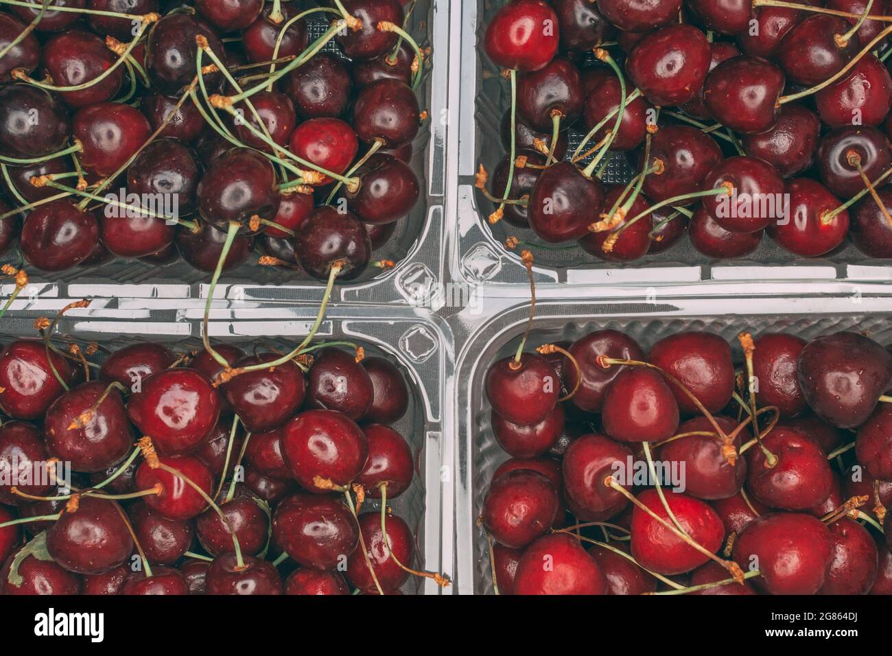 Four plastic containers full of fresh cherries Stock Photo - Alamy