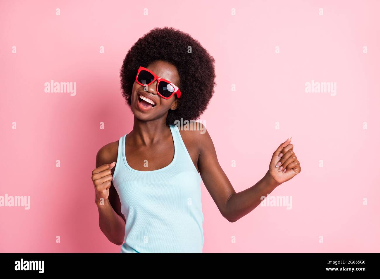 Portrait of optimistic brunette curly lady dance wear spectacles blue ...