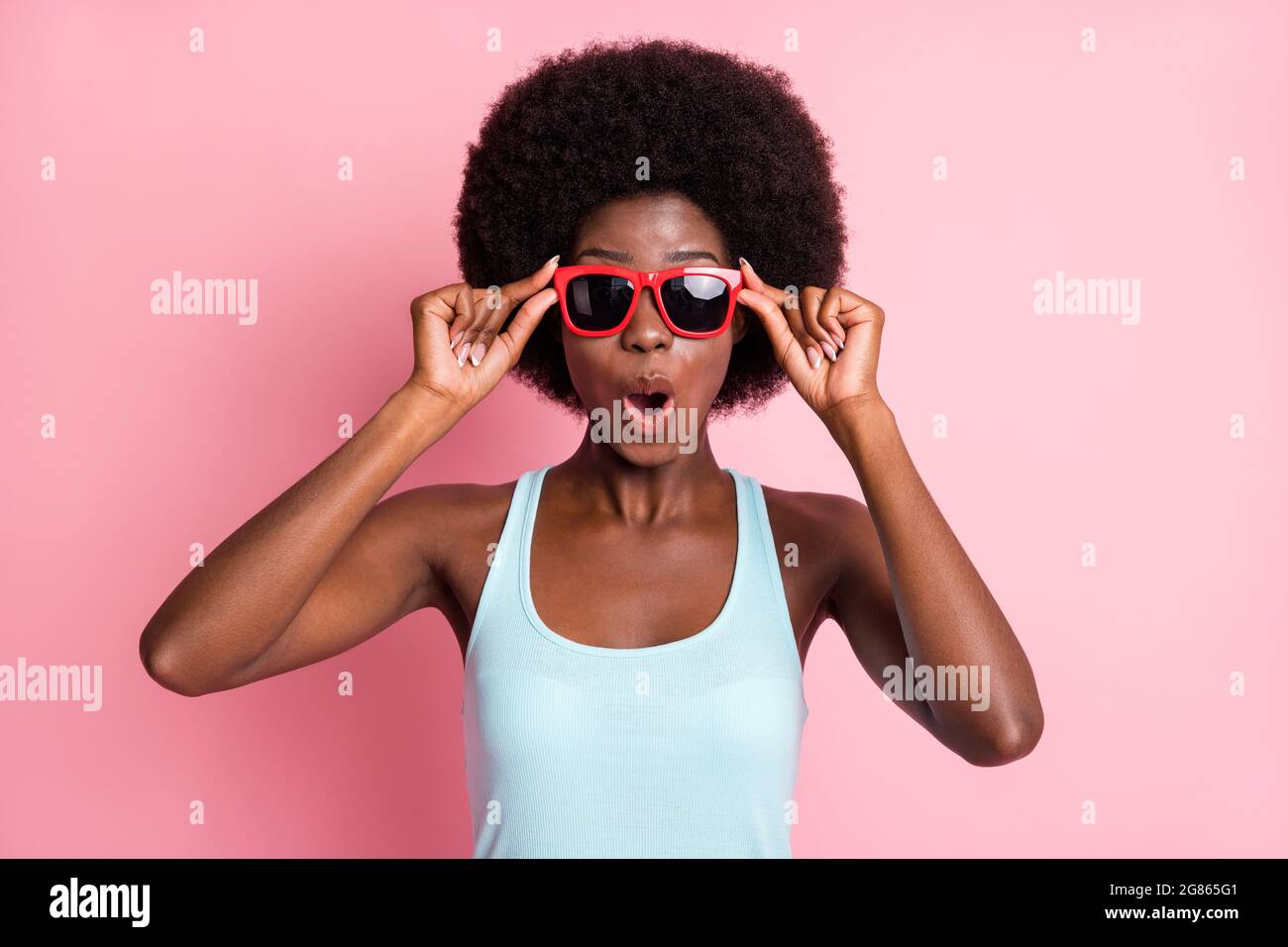 Portrait of impressed brunette curly lady wear spectacles blue top ...