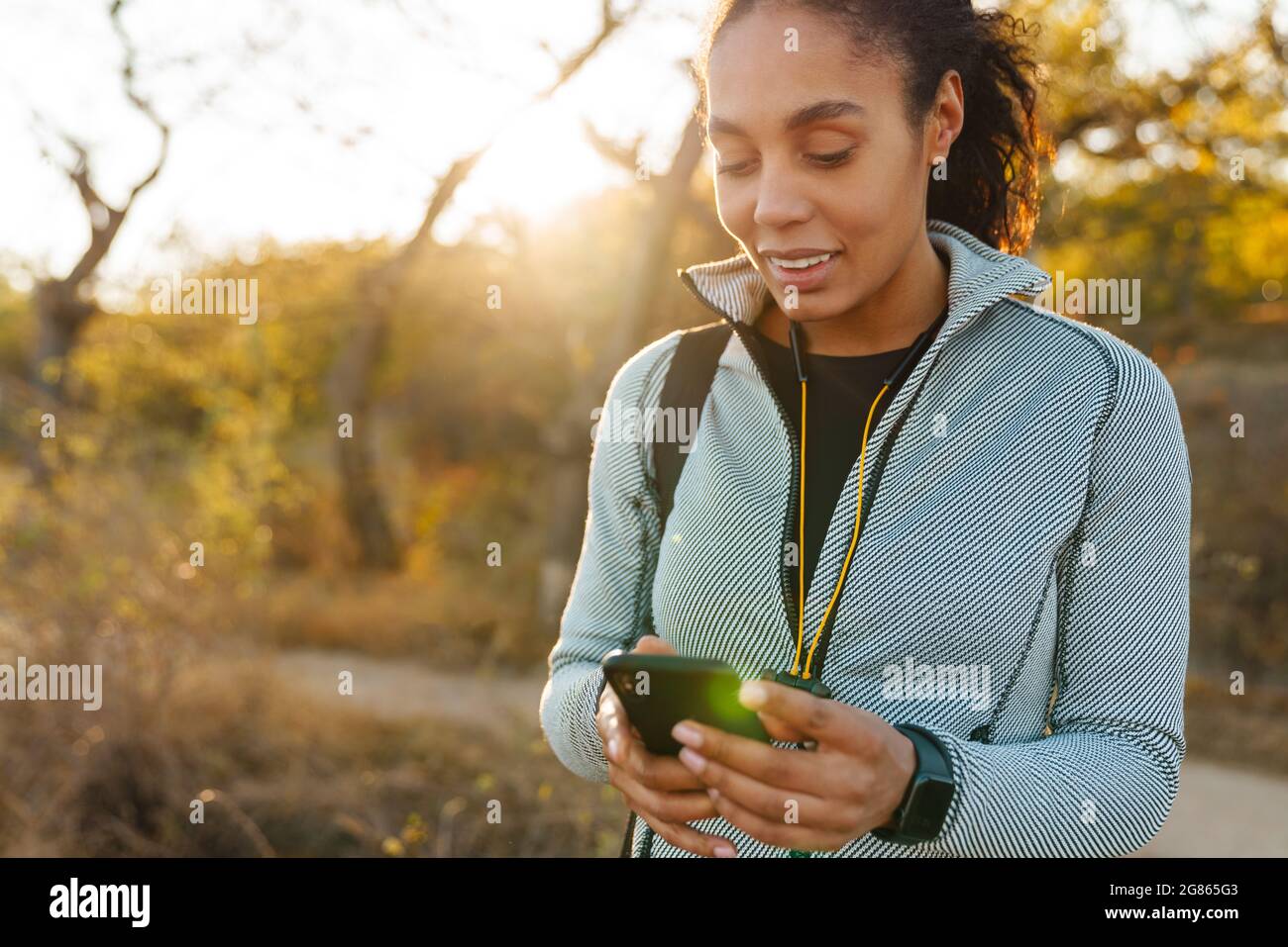 Happy girl walking using phone hi-res stock photography and images - Alamy