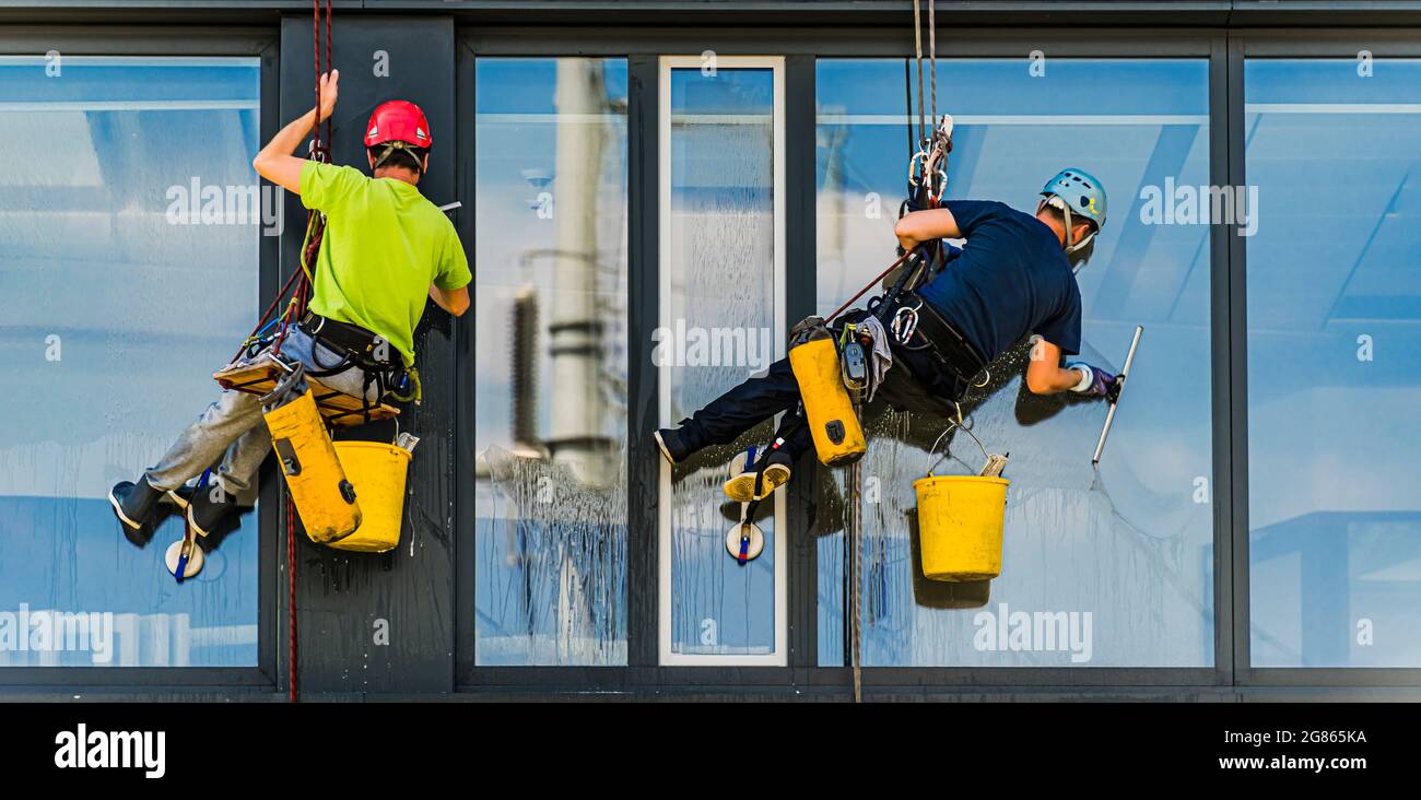 Two men cleaning windows on an office building Stock Photo - Alamy