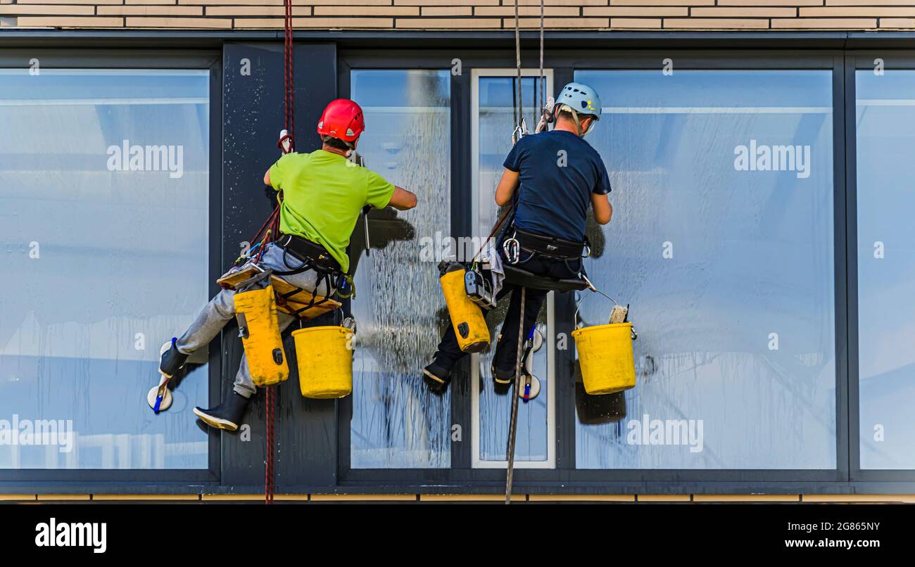 Two men cleaning windows on an office building Stock Photo - Alamy