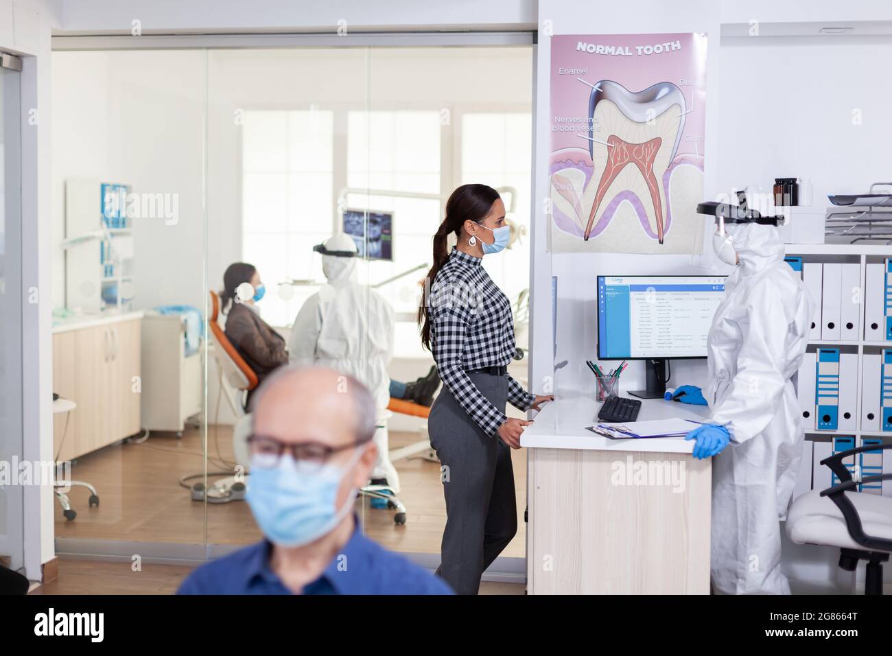 Dentist nurse dressed in ppe suit with face shiled discussing with ...