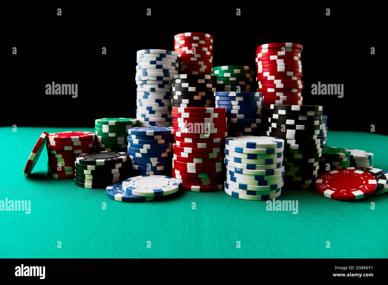 Stack of Casino gambling chips on green table Stock Photo - Alamy