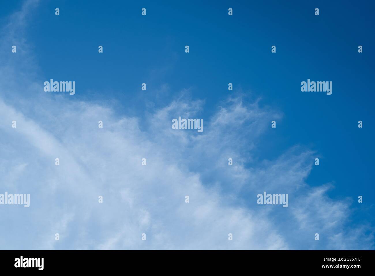 Whispy white clouds and blue sky diving frame diagonally with negative ...