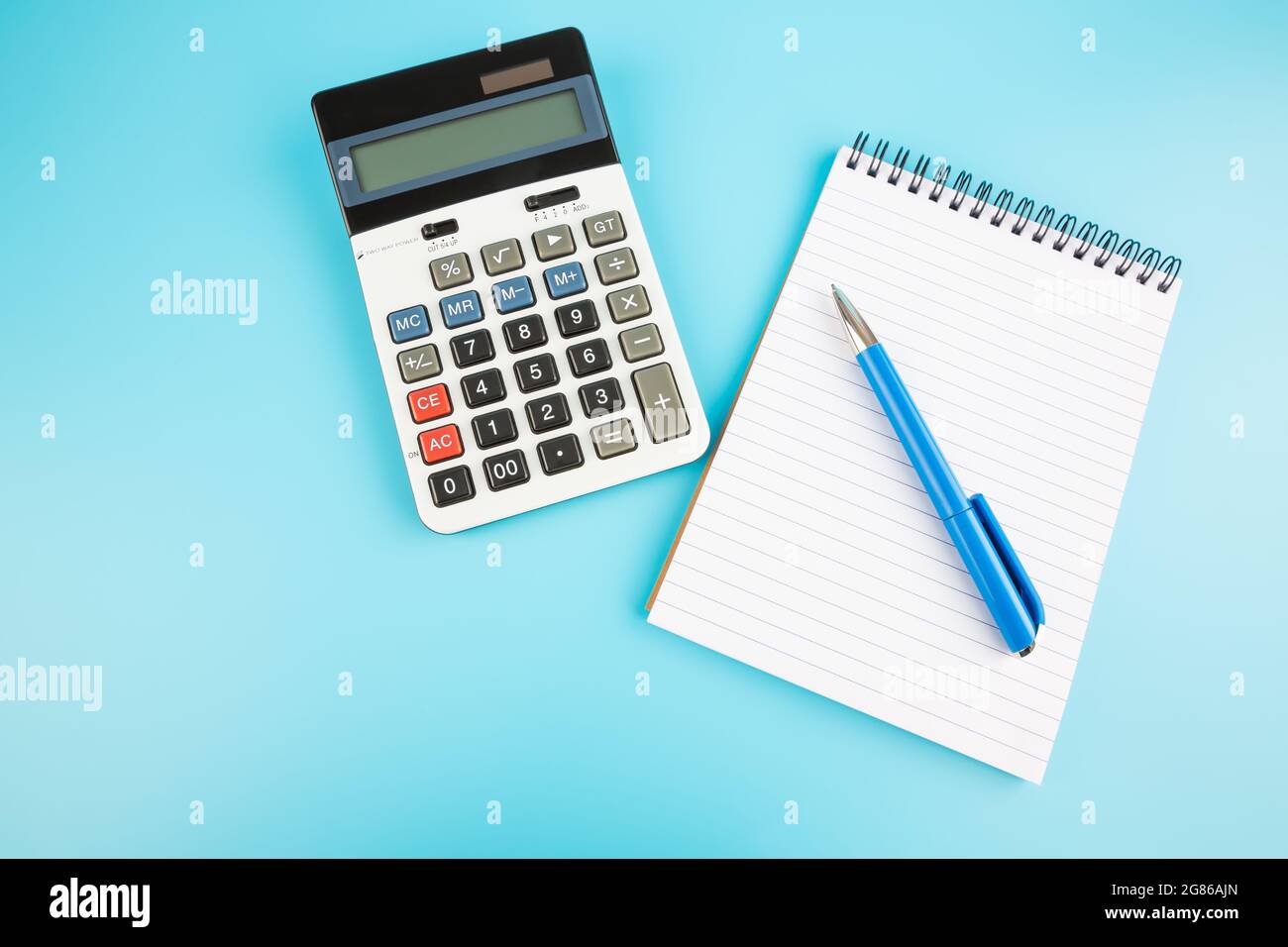 Calculator, blue pen and notepad on blue background Stock Photo - Alamy