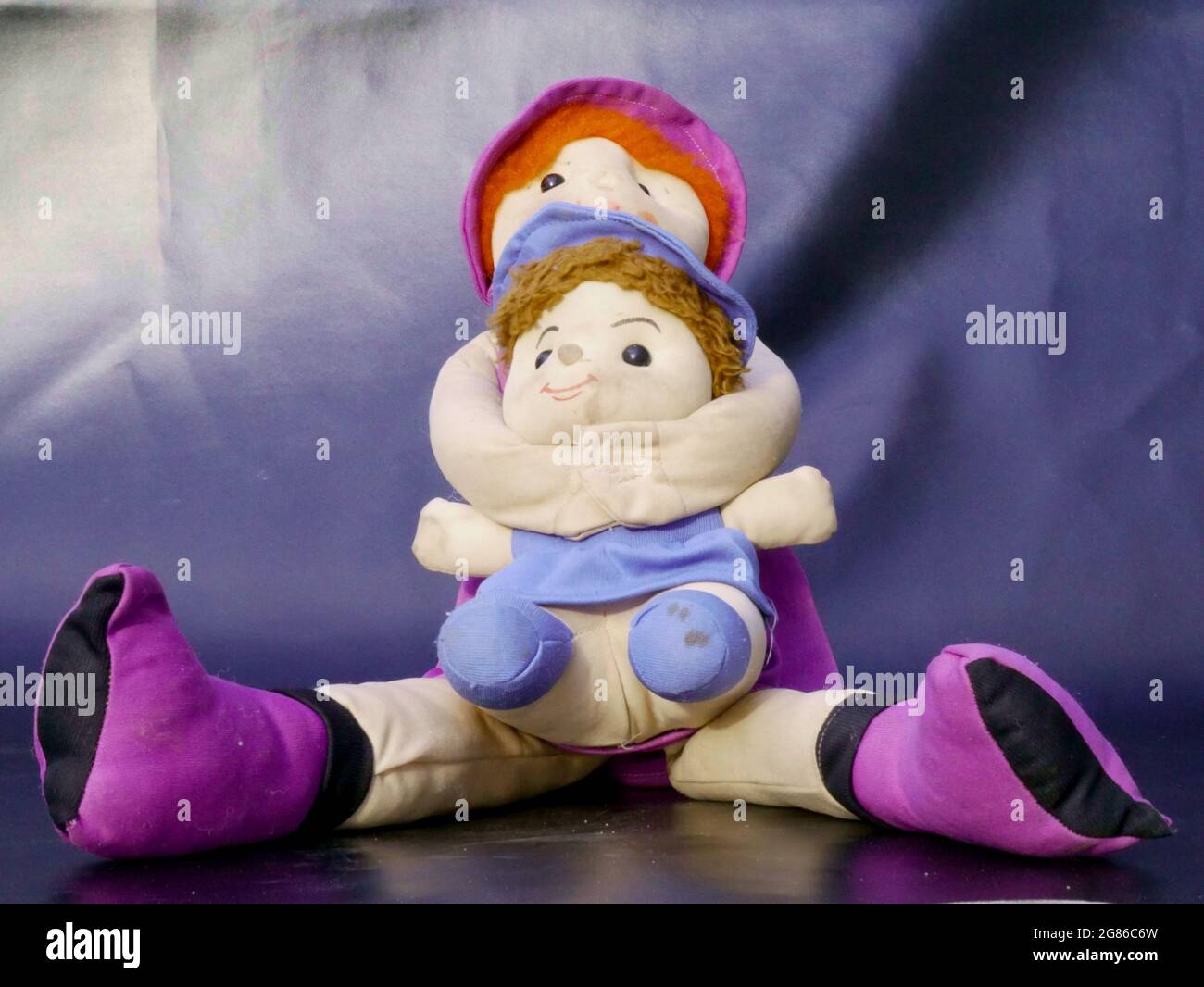 Two soft toy dolls presented together isolate on gray background, kids ...