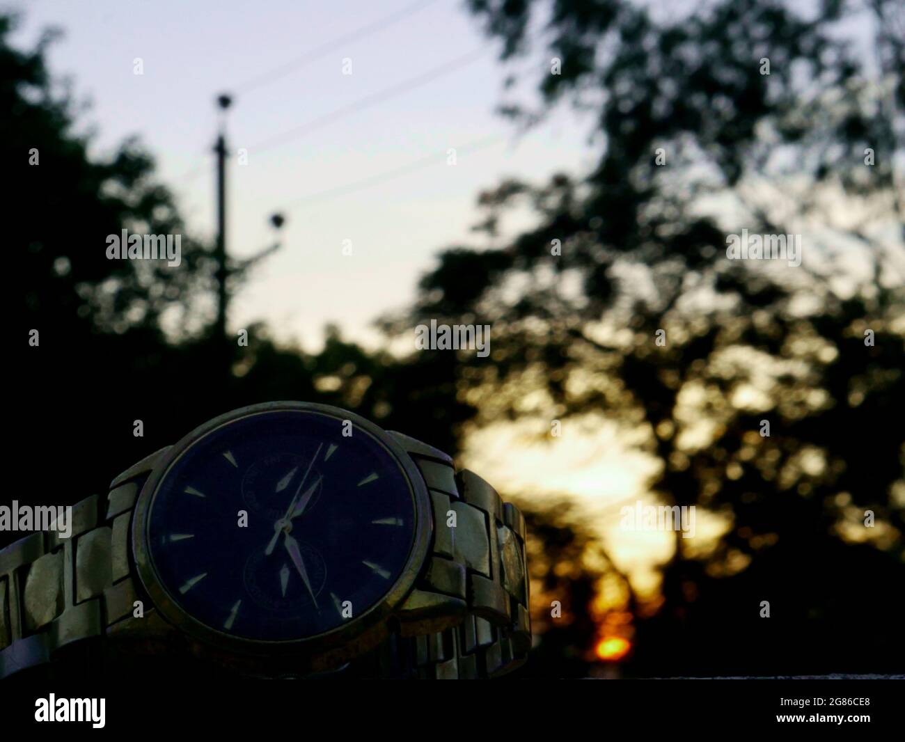 Gents wrist watch displayed with natural weather sunset sky background ...
