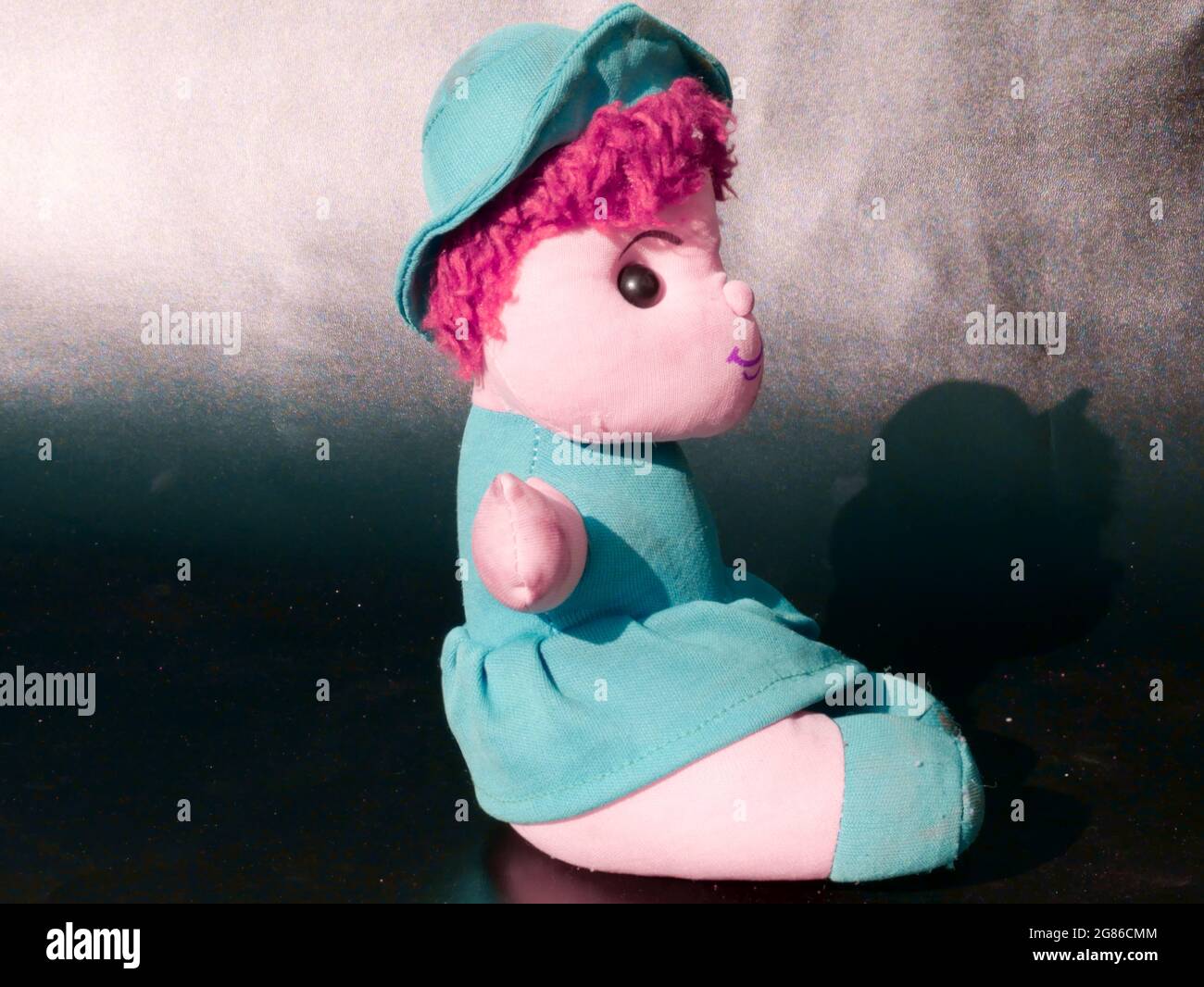 Female soft toy side view on shiny black background, kids playing ...