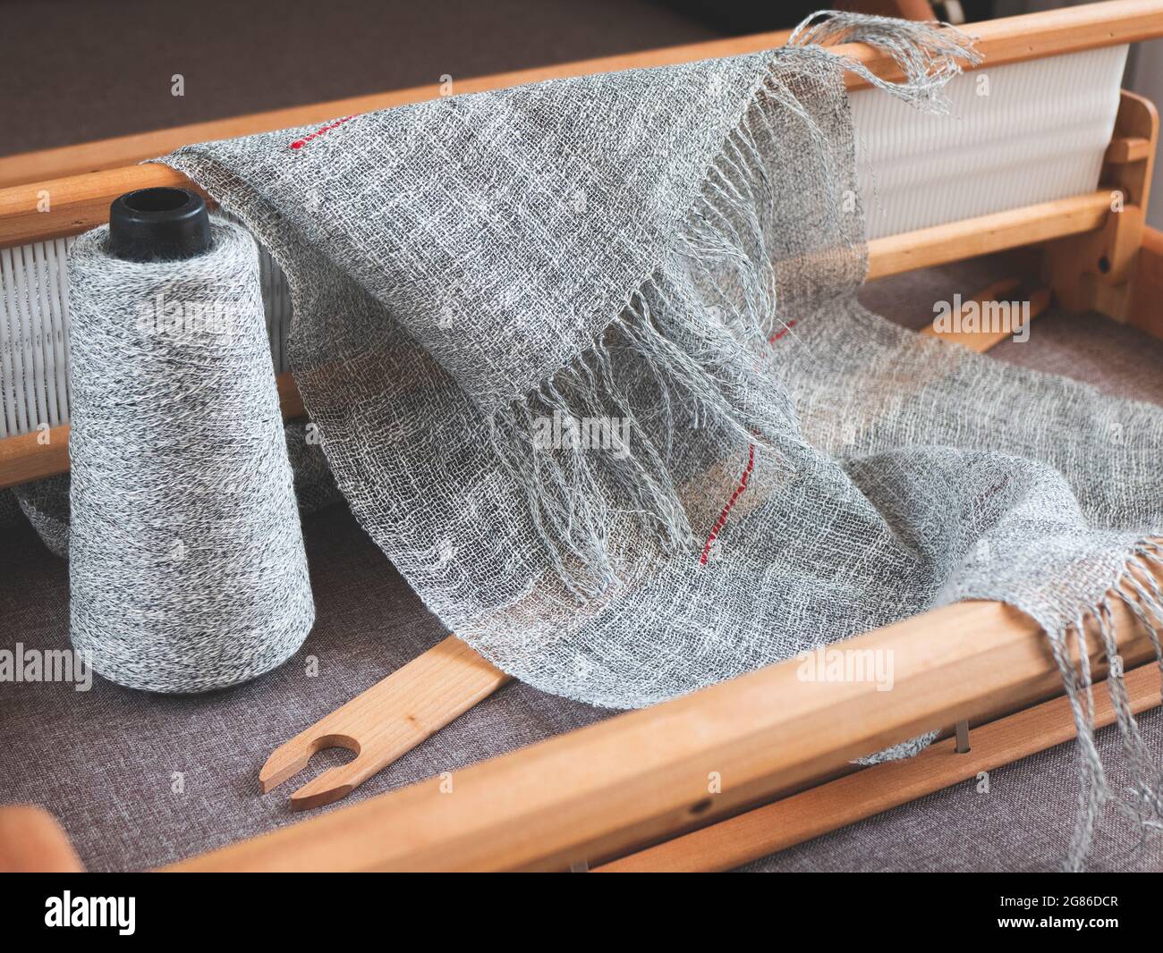 Wooden handloom, reed, shuttle, bobbin with linen yarn and piece of ...