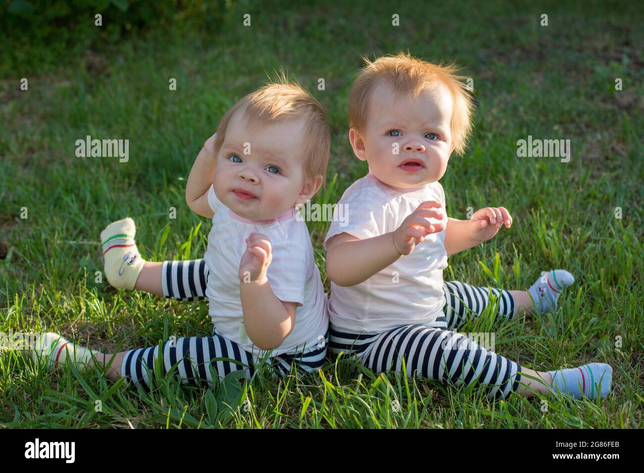 Twin sisters sitting back back hi-res stock photography and images - Alamy
