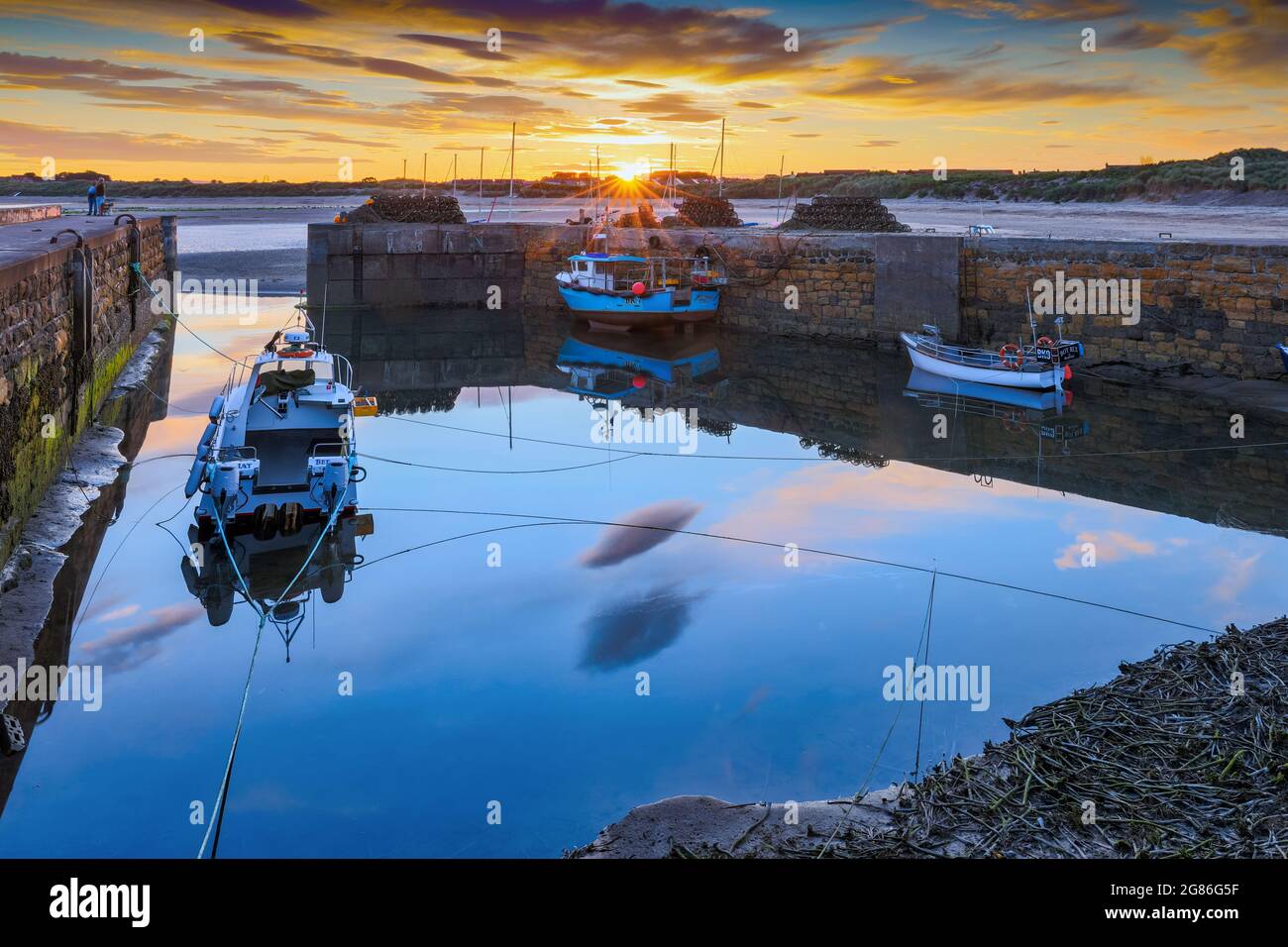 A colourful sunset at the small harbour at Beadnell, the only west ...