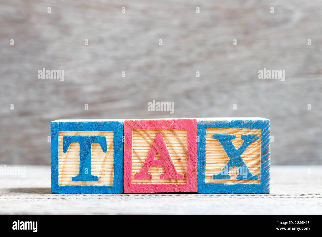 Color letter block in word tax on wood background Stock Photo - Alamy