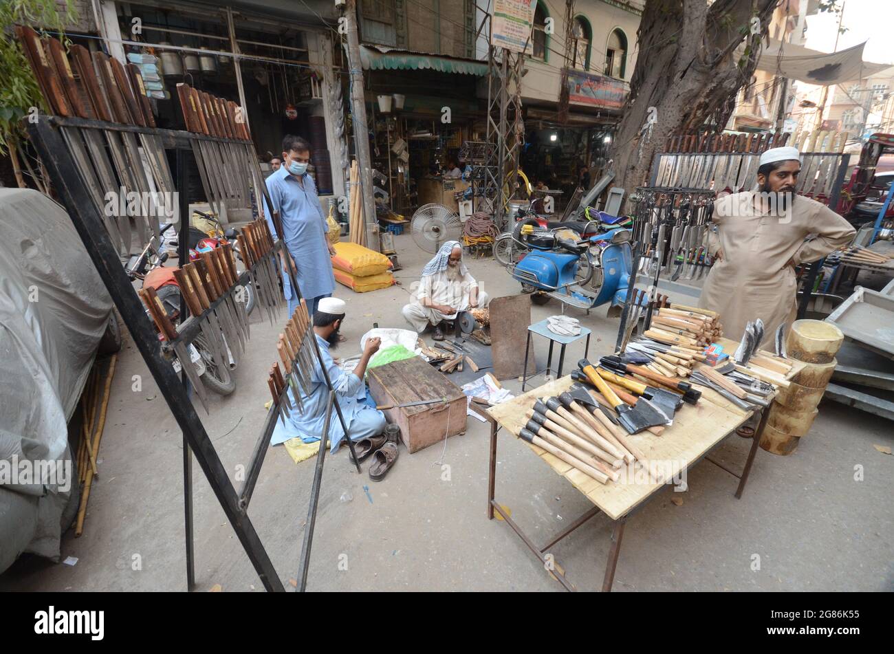 Peshawar, Pakistan. 17th July, 2021. A Pakistani vendor sharpen axe ...
