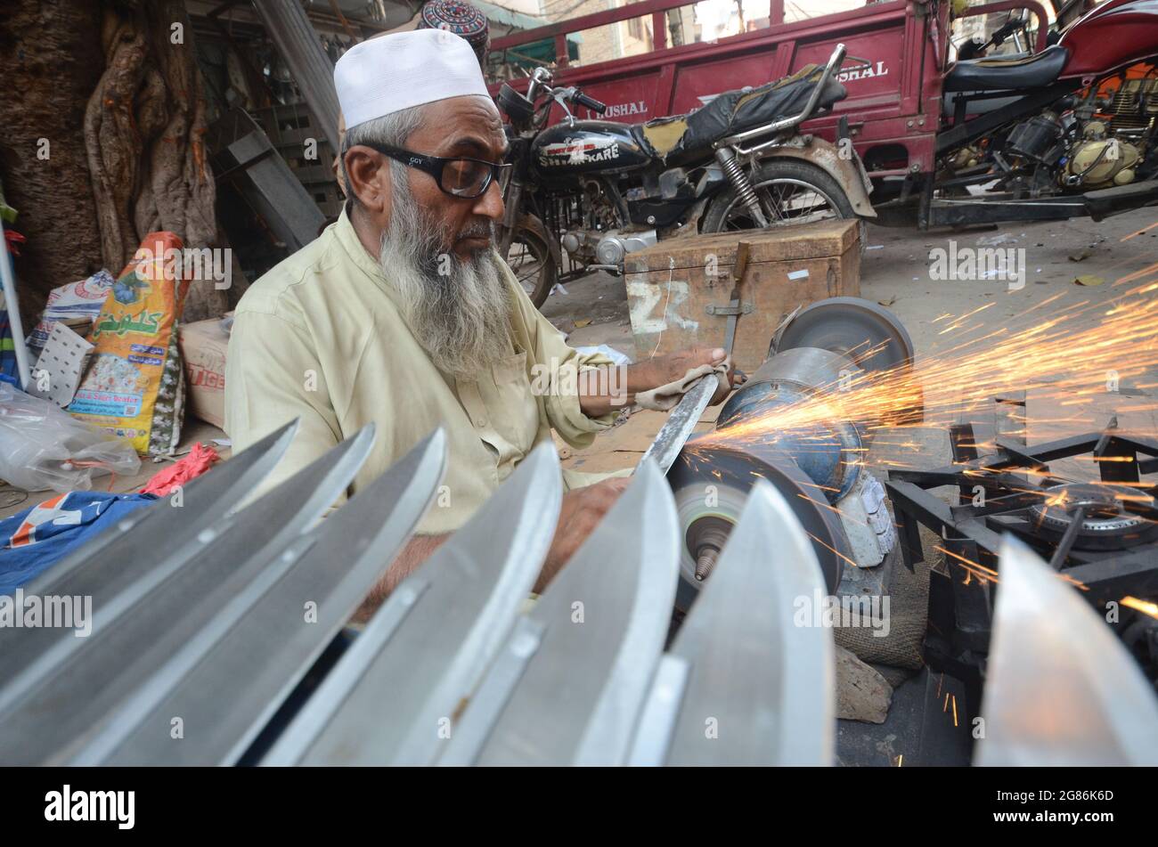 Peshawar, Pakistan. 17th July, 2021. A Pakistani vendor sharpen axe ...