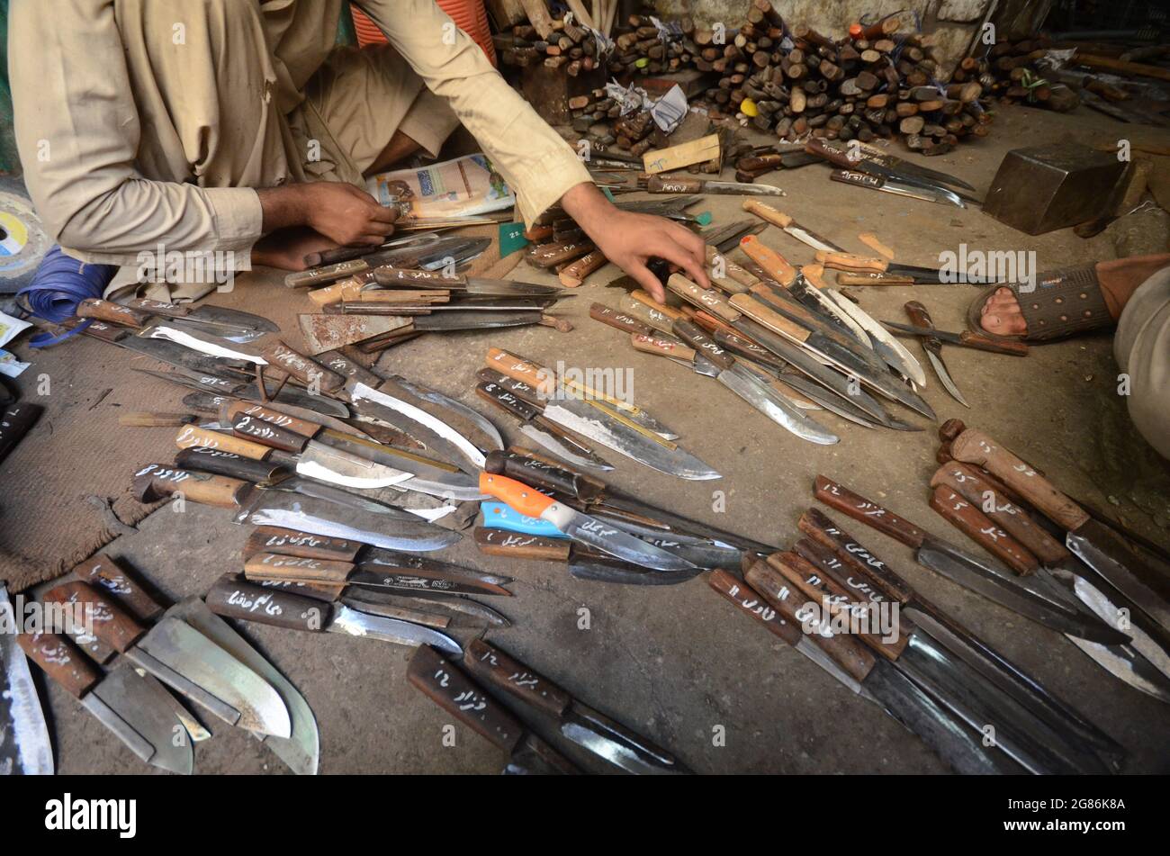 Peshawar, Pakistan. 17th July, 2021. A Pakistani vendor sharpen axe ...