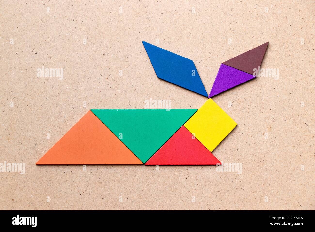 Color tangram in rabbit shape on wood background Stock Photo - Alamy