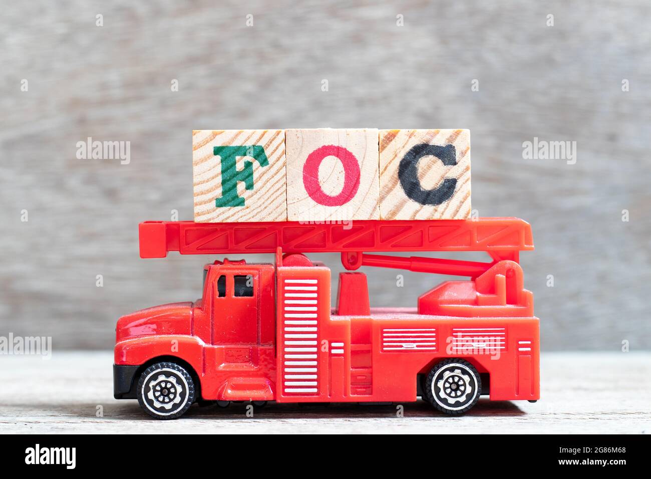 Red fire truck hold letter block in word FOC (Abbreviation of Free of ...