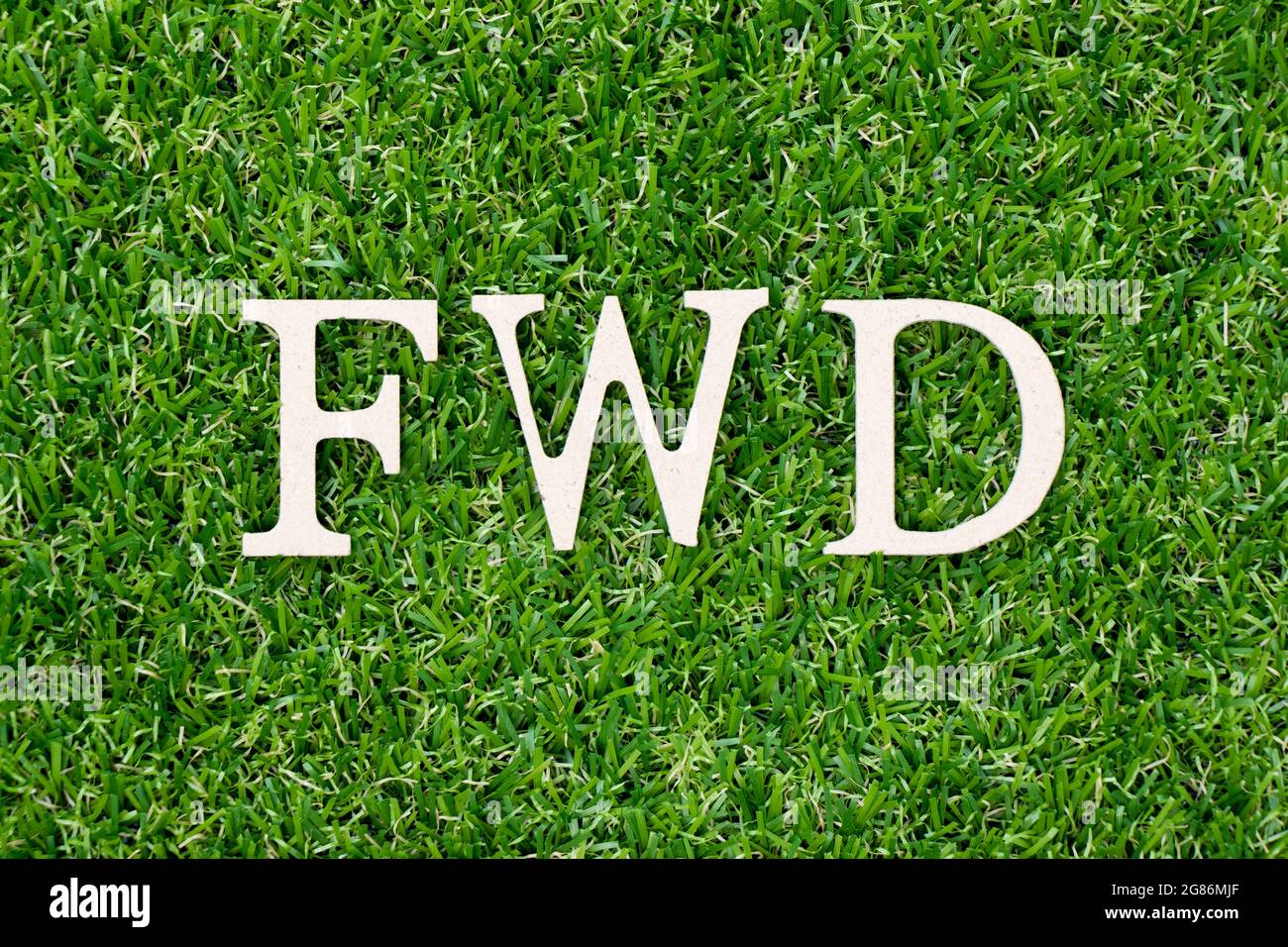 Wood letter in word FWD (Abbreviation of forward) on green grass ...