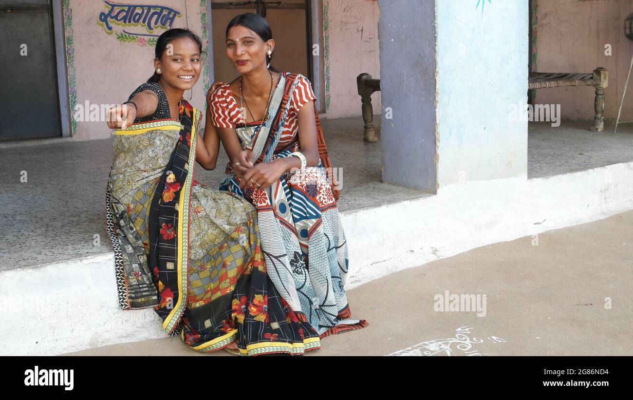 South Asian women wearing traditional costumes and looking at something ...