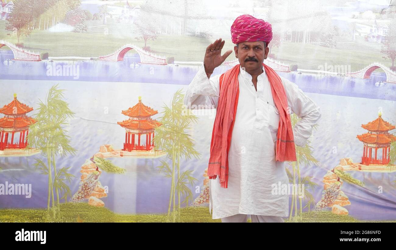 Old South Asian man wearing a traditional costume and saluting with his ...