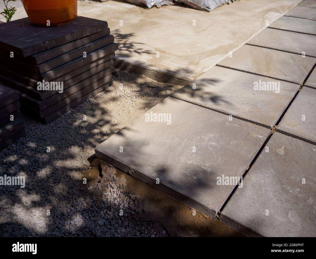 Laying patio slabs and landscaping a new outdoor floor in a garden ...