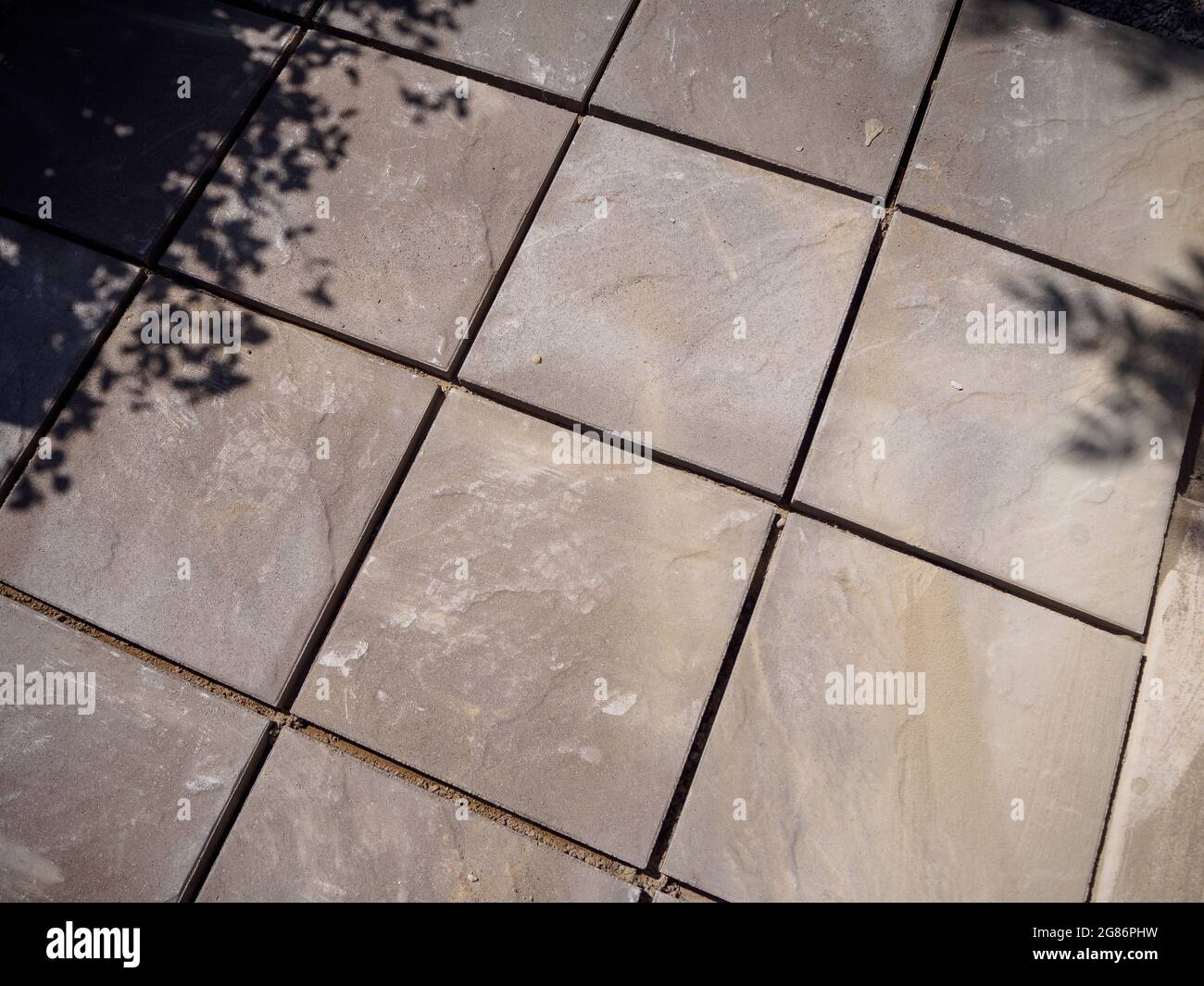 Laying patio slabs and landscaping a new outdoor floor in a garden ...