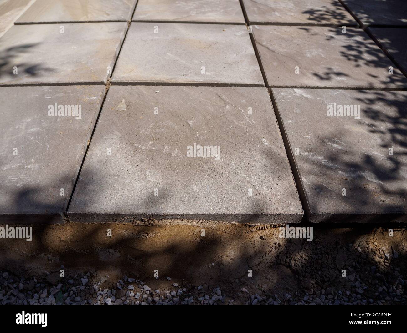 Laying patio slabs and landscaping a new outdoor floor in a garden ...