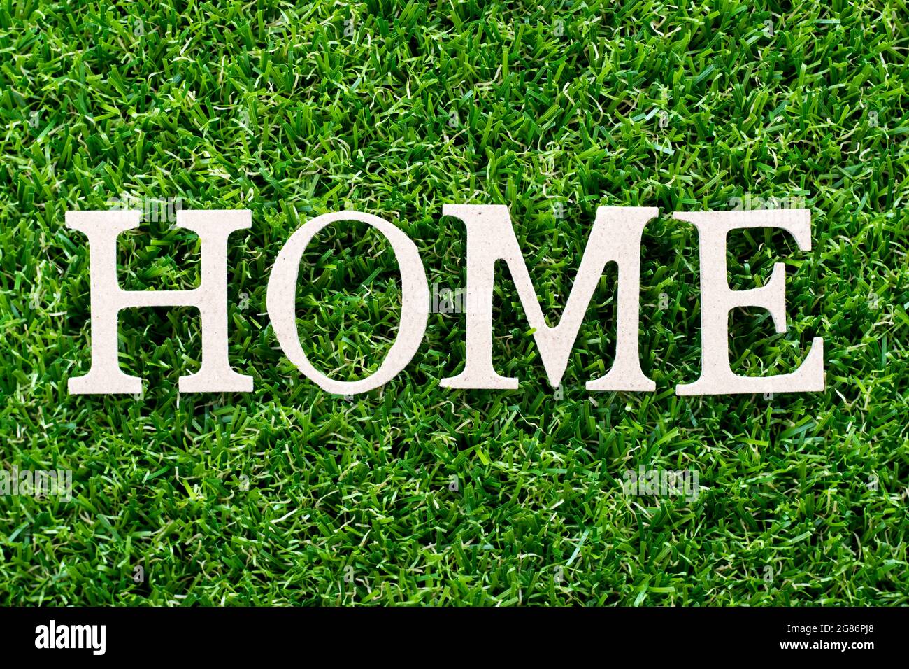 Wood letter in word home on artificial green grass background Stock ...