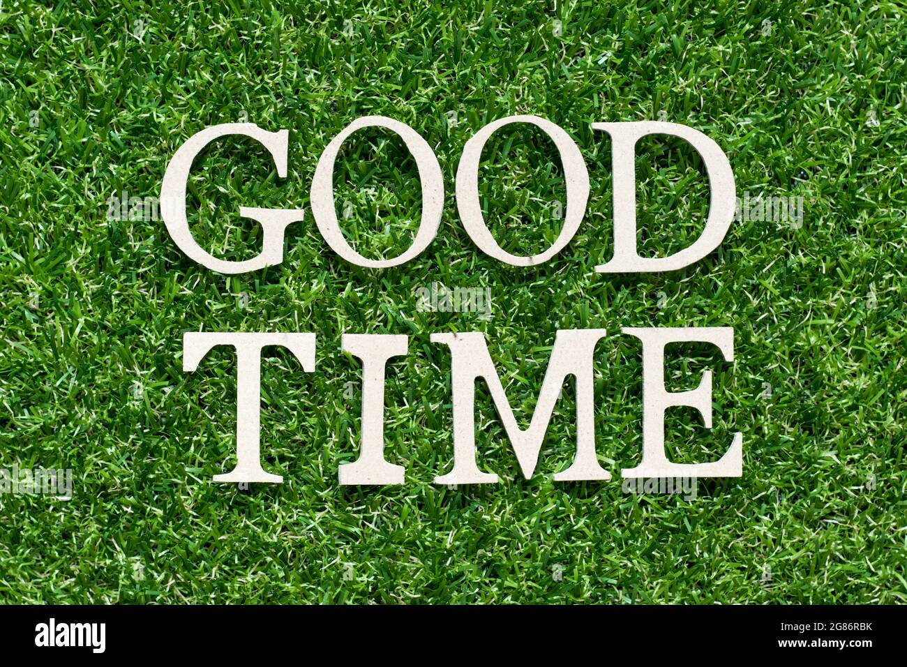 Wood alphabet letter in word good time on artificial green grass ...