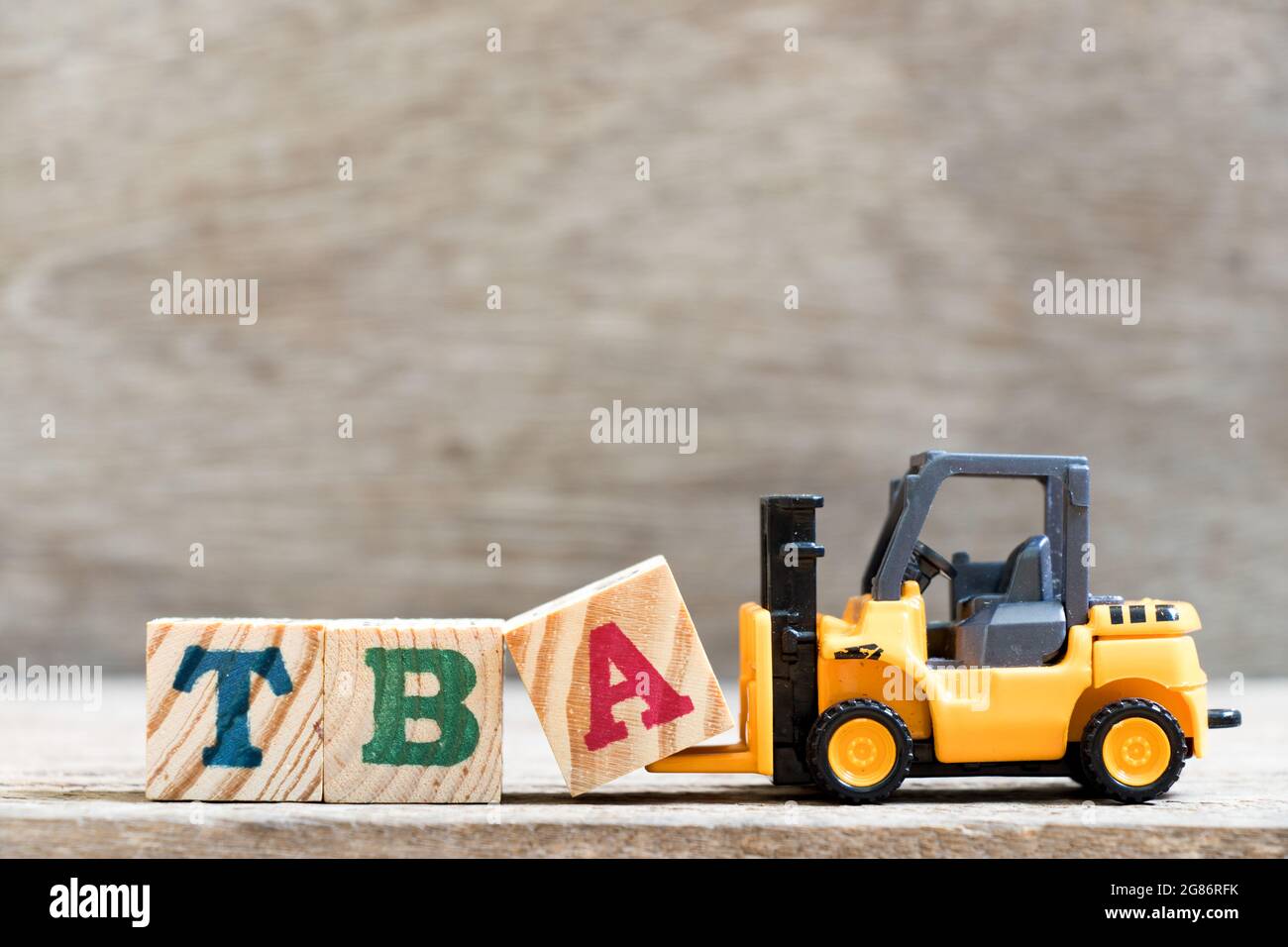 Toy forklift hold letter block in word TBA (abbreviation of to be ...